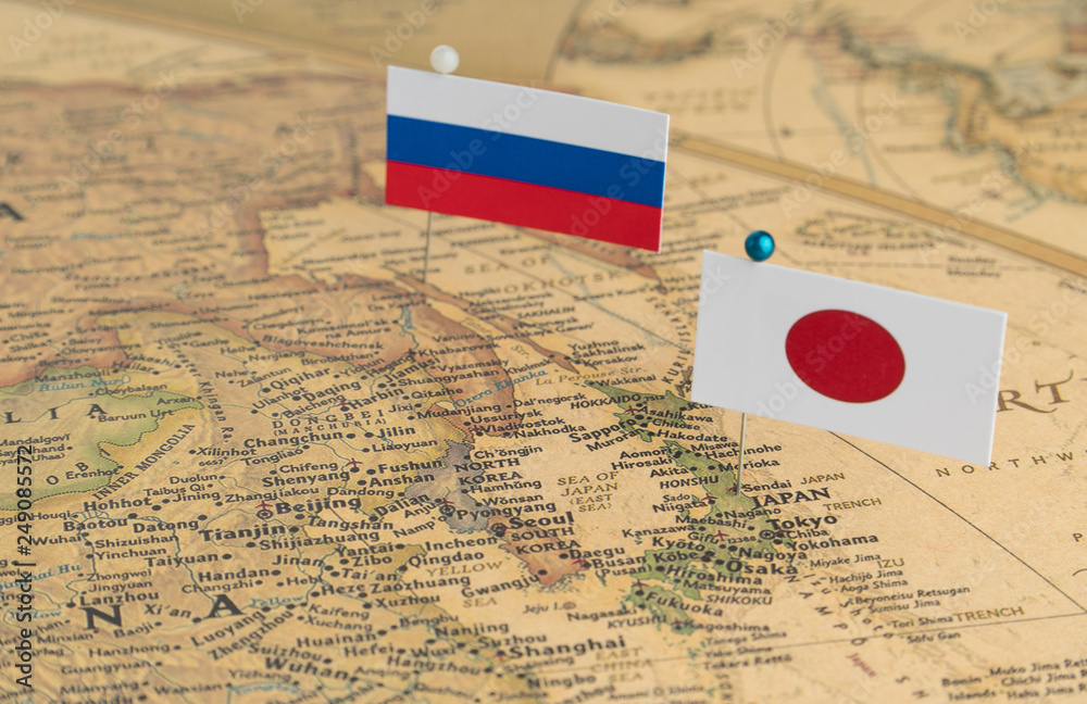 The flags of Russia and Japan on the world map. Conceptual photography ...