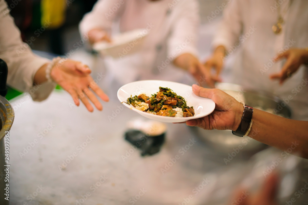 The hand of a beggar received food from a compassionate person : giving ...