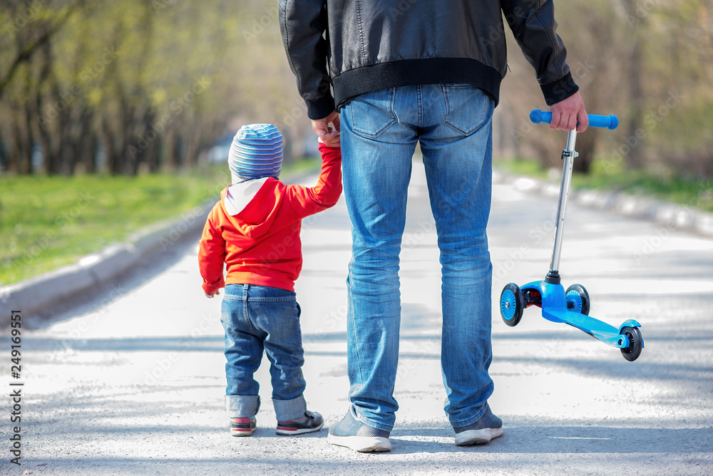 Foto de Little toddler boy on a walk with his father, view from behind ...