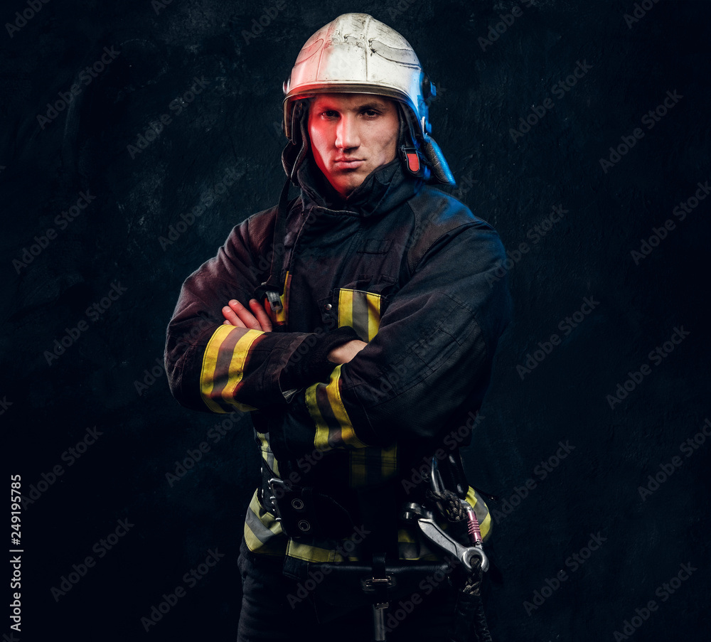 Brutal fireman in uniform posing for the camera standing with crossed ...