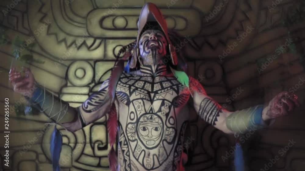 Creepy aztec warrior getting ready before the battle, screaming and ...