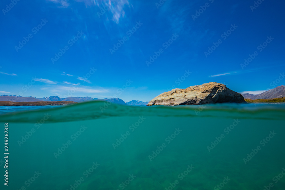 half over half under the water surface at lake tekapo in New Zealand ...
