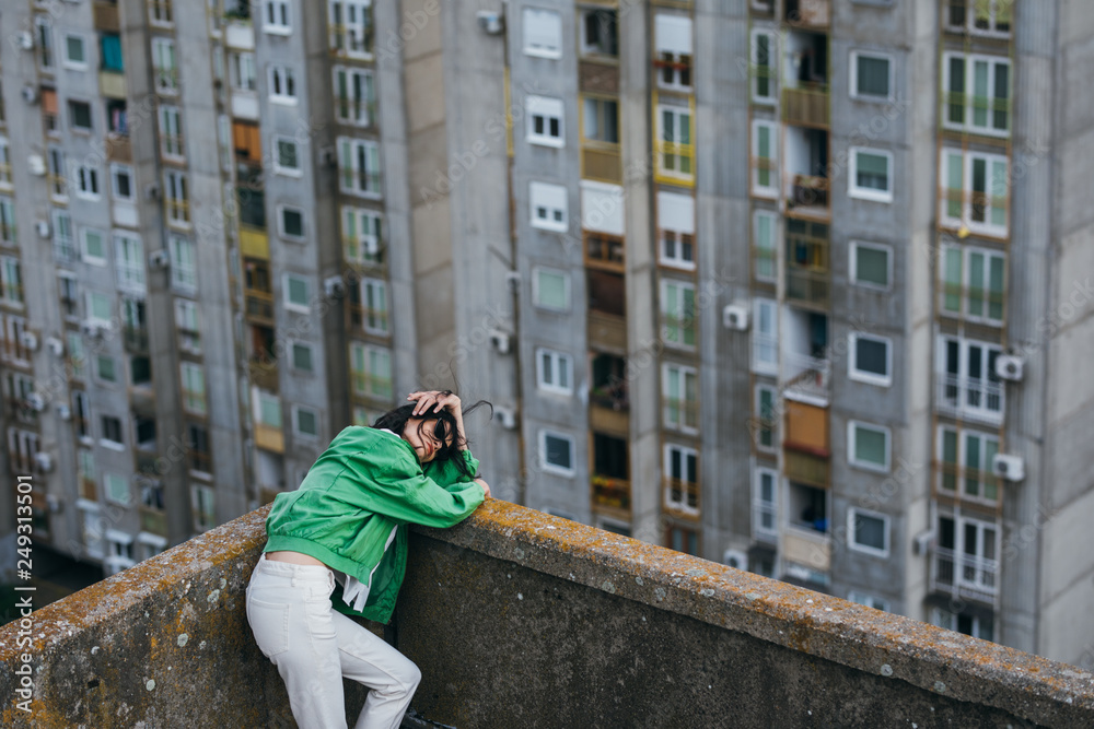 Pretty woman fashion model posing on residential building rooftop ...