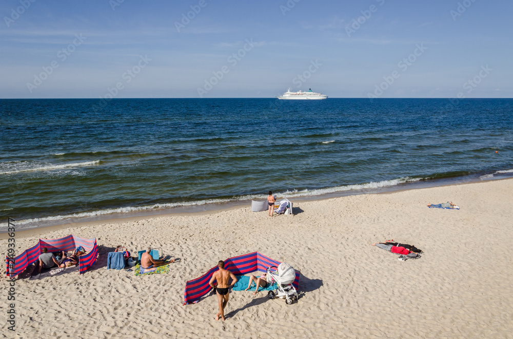 REST ON THE SEA BEACH - People on golden sand and a cruise passenger ...