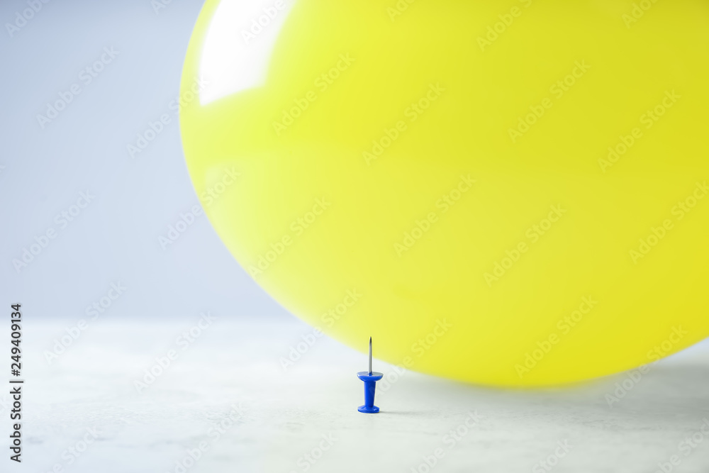 Color balloon and pin on table against white background, space for text ...