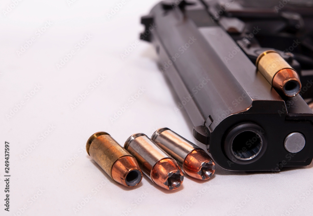 A black 40 caliber pistol with four 40 caliber hollow point bullets on ...