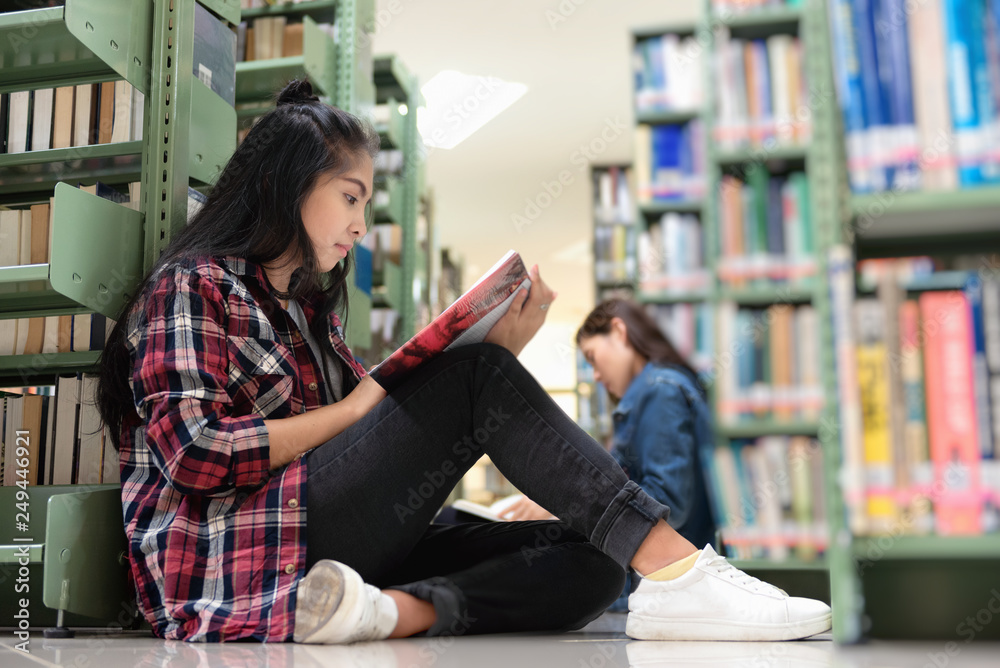 Asian female student sitting on floor in the library, Open and learning ...