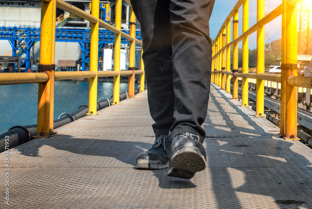 Safety shoe of worker walking in mind step on the steel checker plate ...