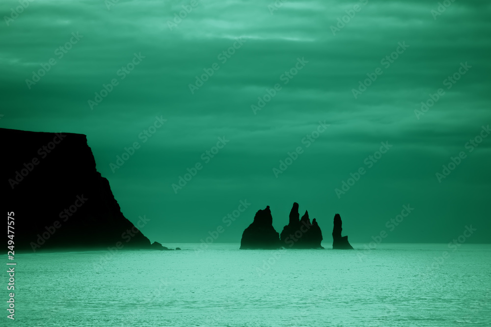 Famous basalt sea stacks of Reynisdrangar, rock formations on the black ...