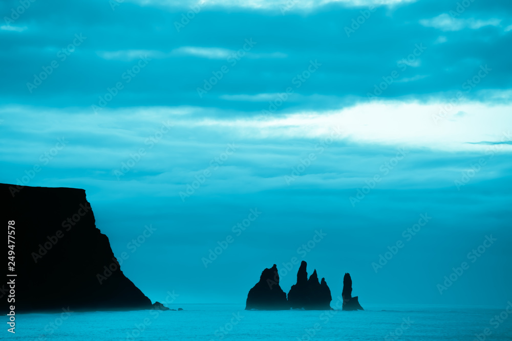 Famous basalt sea stacks of Reynisdrangar, rock formations on the black ...