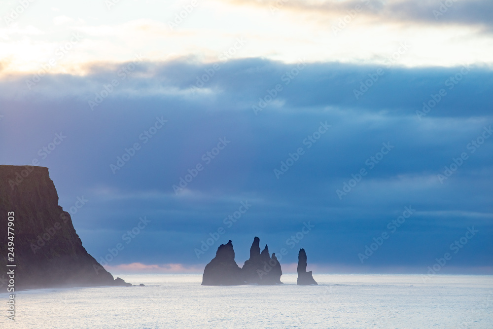Famous basalt sea stacks of Reynisdrangar, rock formations on the black ...