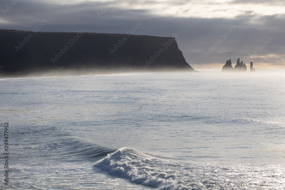 Famous basalt sea stacks of Reynisdrangar, rock formations on the black ...