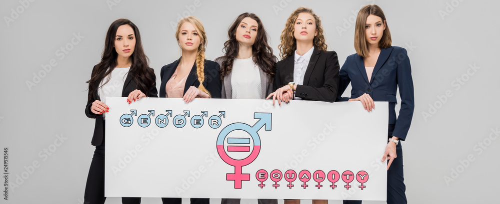 successful young women holding large sign with gender equality symbol ...