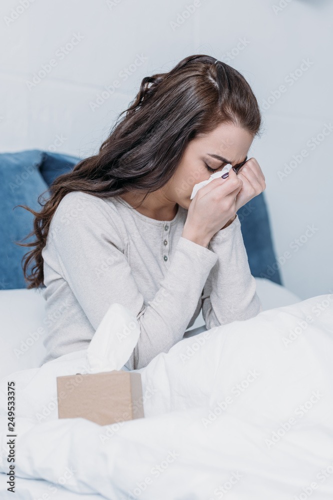 woman lying in bed with tissue box, crying and wiping tears Stock Photo ...