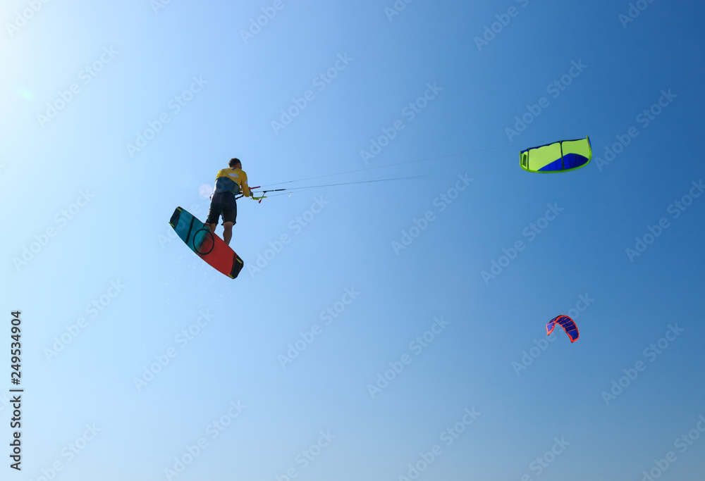 Professional kite boarding rider sportsman with kite in sky jumps high ...