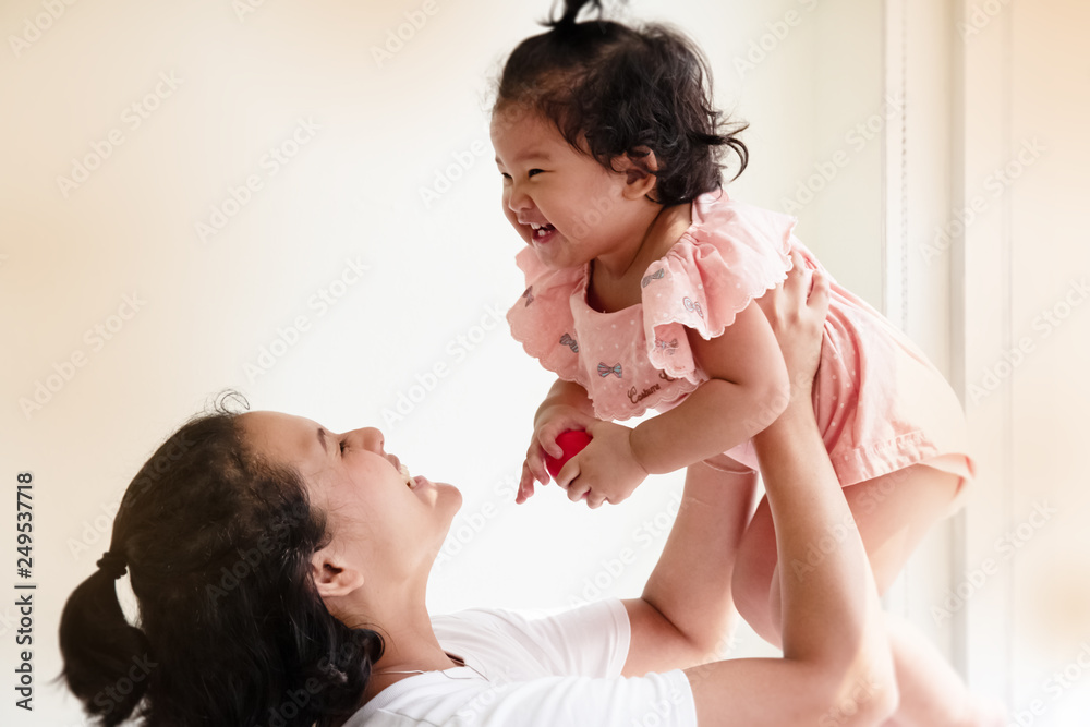 Mother raise her dauther up in the air,playing togetherness,with smile ...