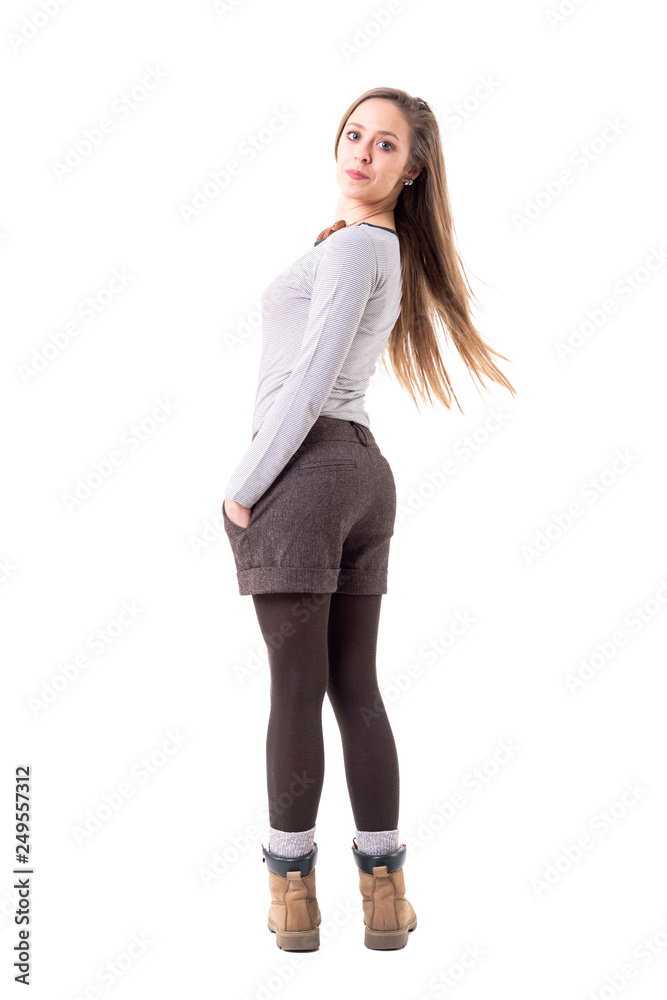 Rear view of charming playful cute young woman turning at camera ...