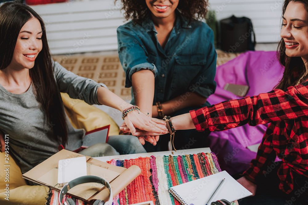 Three girls putting arms together denoting collaboration Stock Photo ...