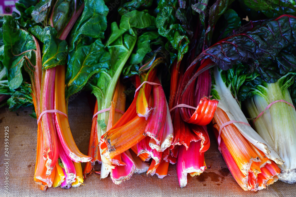 Bunches of rainbow Swiss chard with bright red and orange stalks and ...