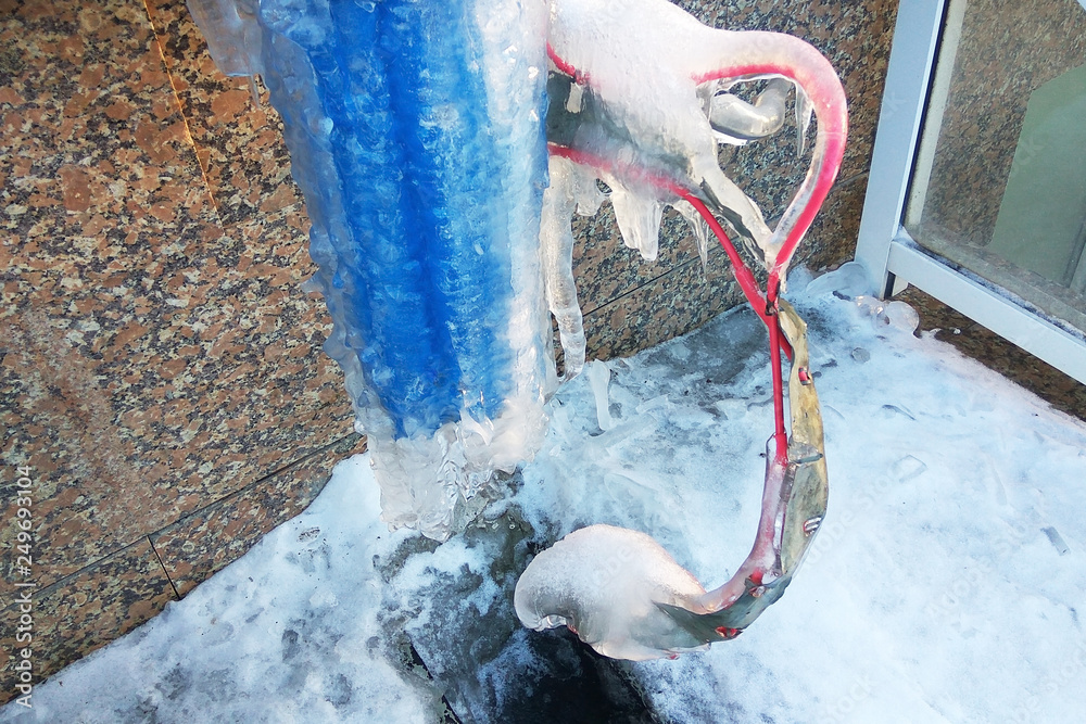 Dangerous frozen electricity wires in tube covered with ice in winter ...