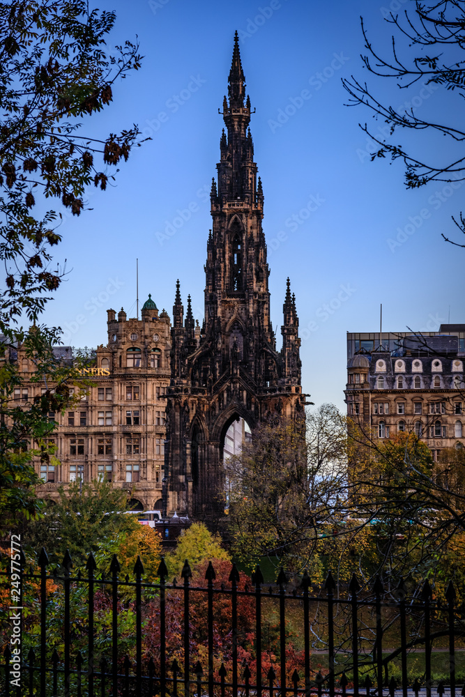 The Scott Monument in Edinburgh Scotland stands tall and dark between ...