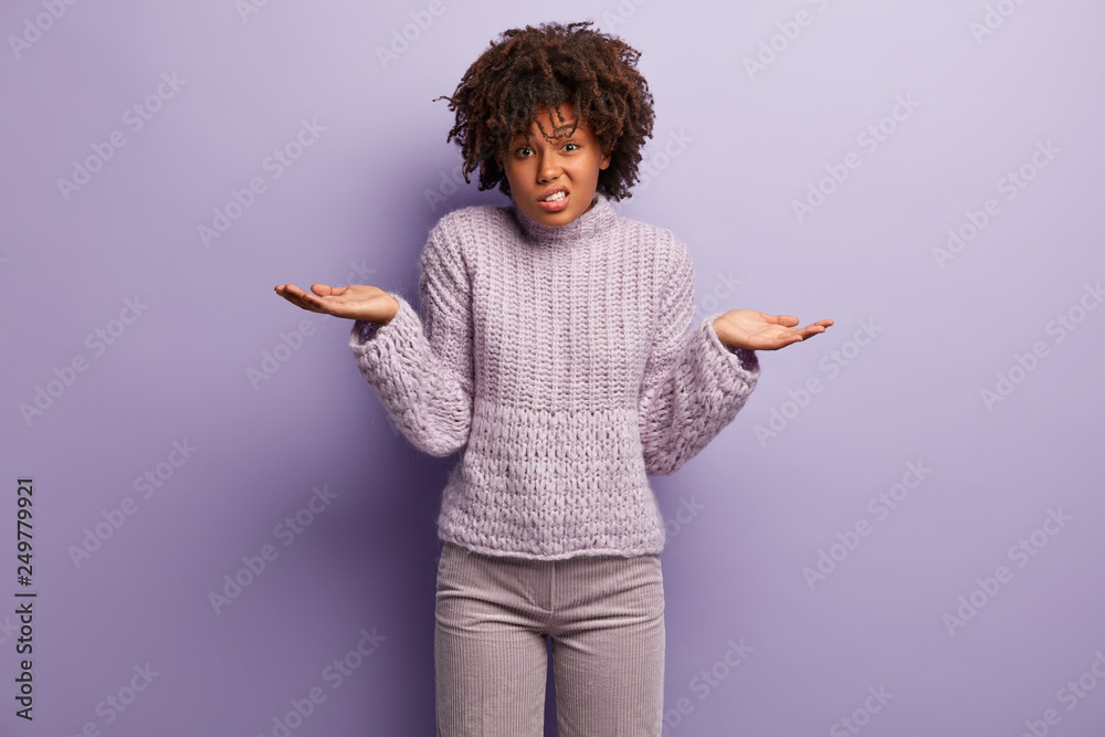 Photo of puzzled dark skinned lady faces dilemma, spreads palms with ...