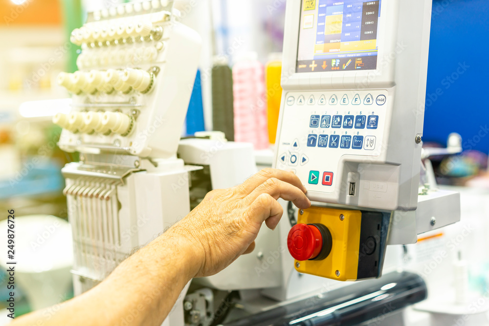 Operator or tailor working on control panel of modern and automatic ...