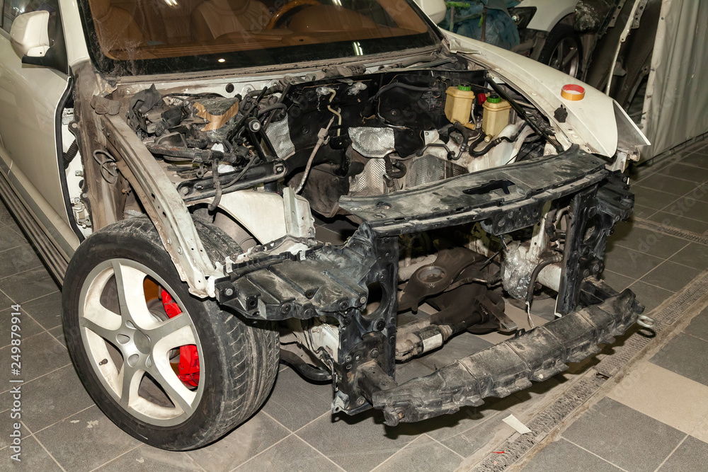 Disassembled white car in the workshop prepared for repair: front end ...