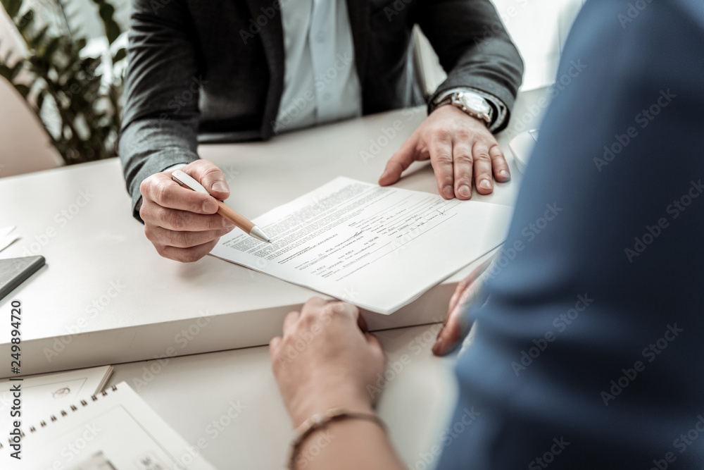 Man with a watch on his hand showing the place for signature to the ...