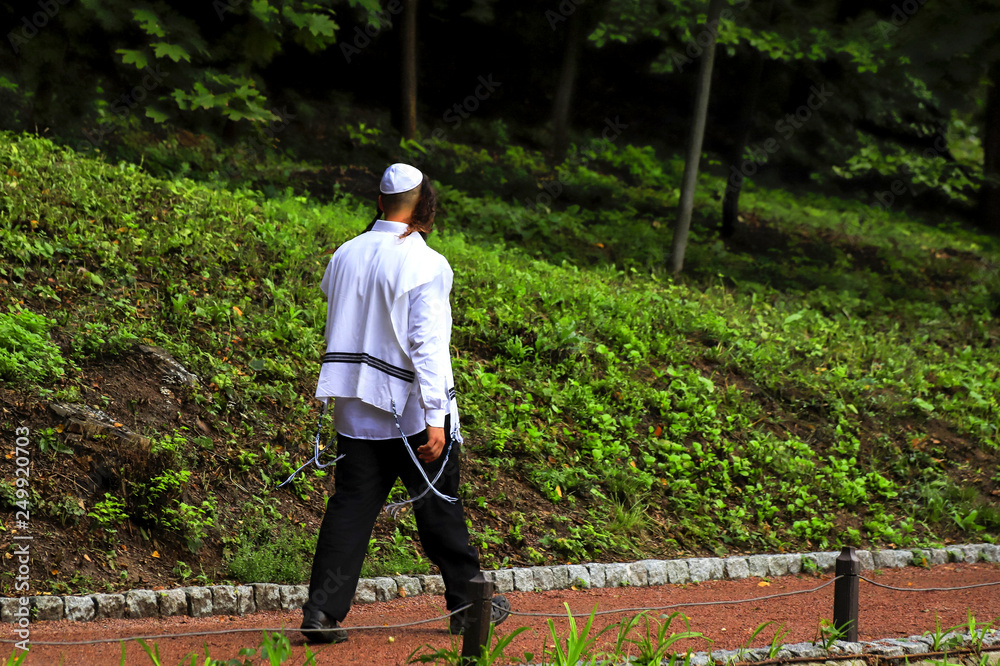 A young Jew Hasid man walking in the park, the time of the Jewish New ...