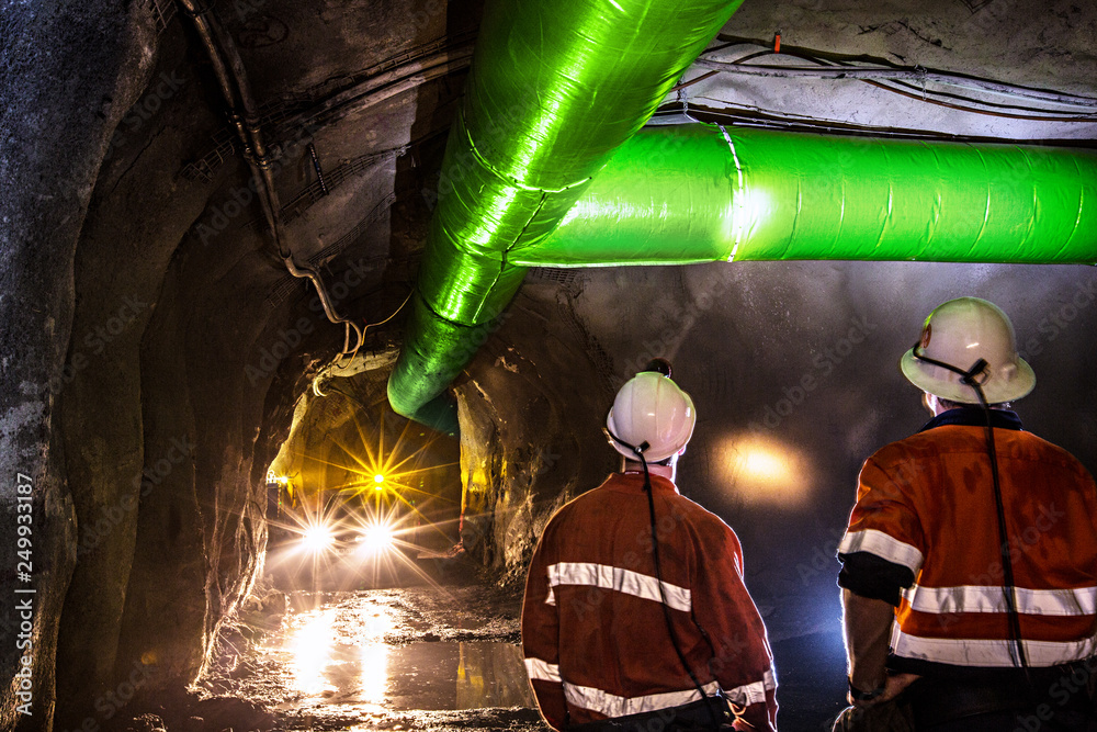 Miners inspecting an underground ventilation system in a gold mine in ...