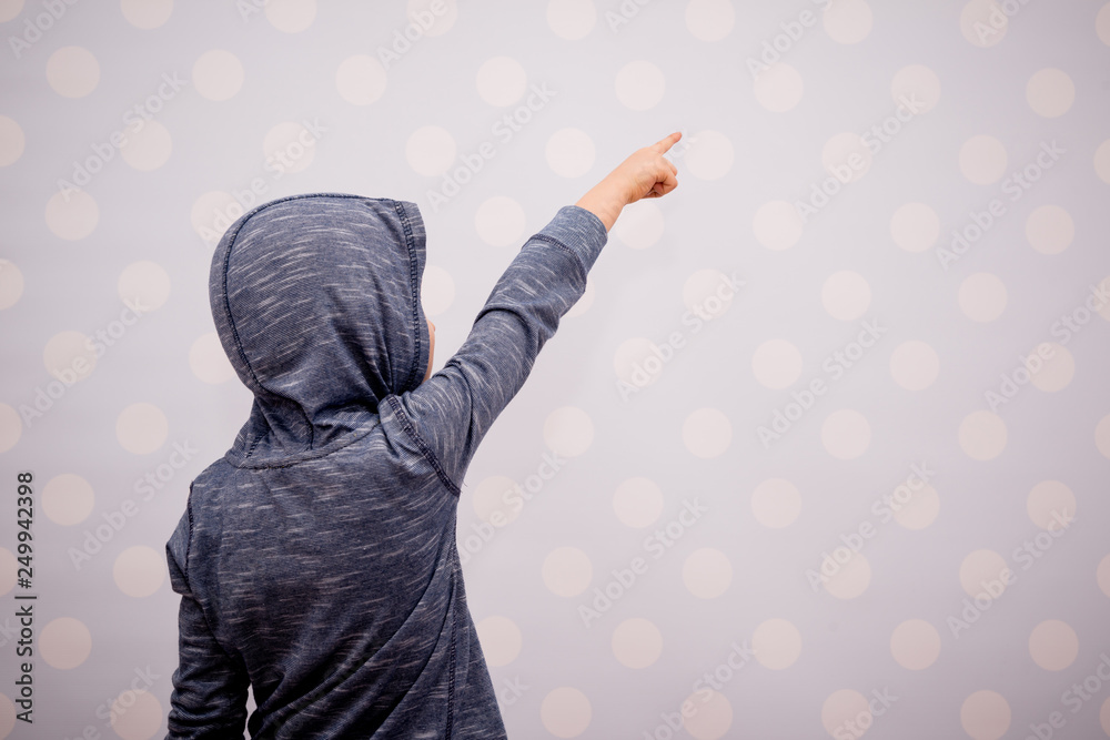 Pointing with a finger by a boy. A small child with his back turned ...