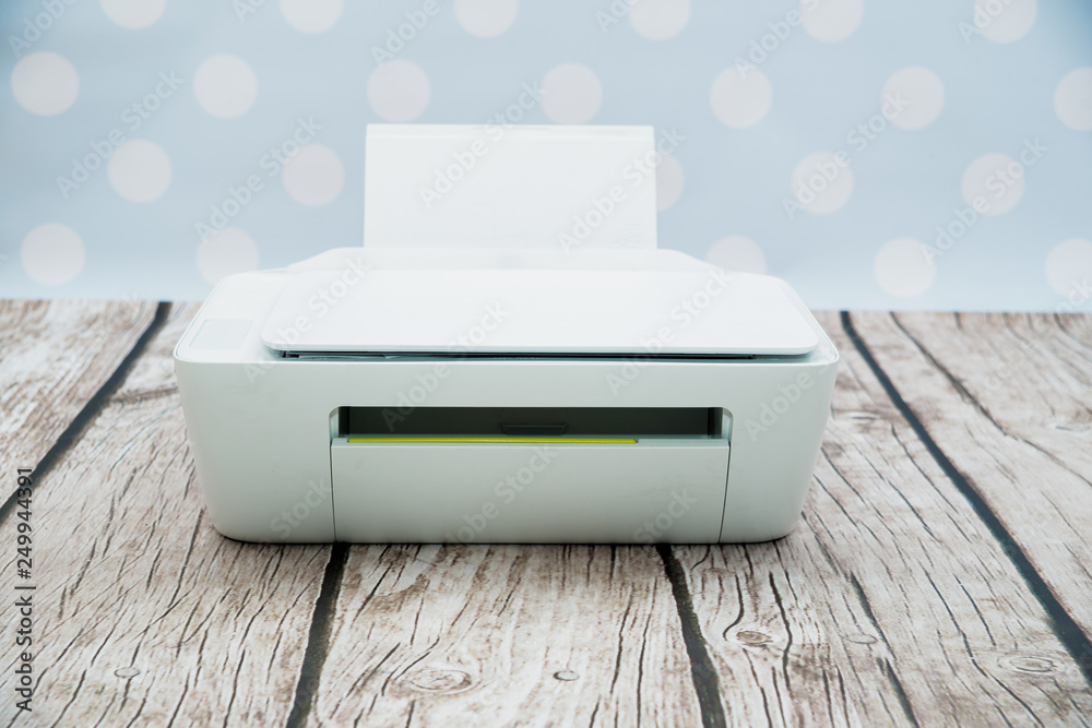 White printer on a bright, pastel blue background. The concept of using ...