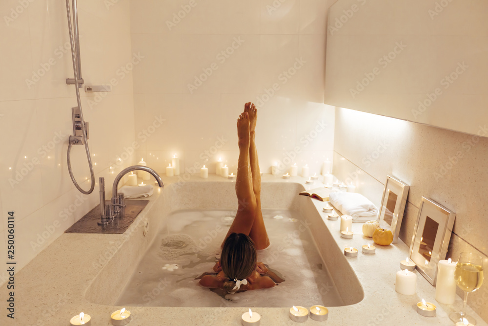 Woman relaxing in bath with candles Stock Photo | Adobe Stock