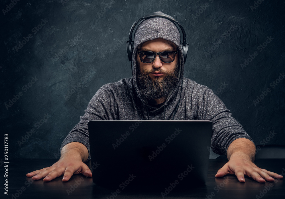 Bearded hacker in a cap and sunglasses hacked the bank and put his ...