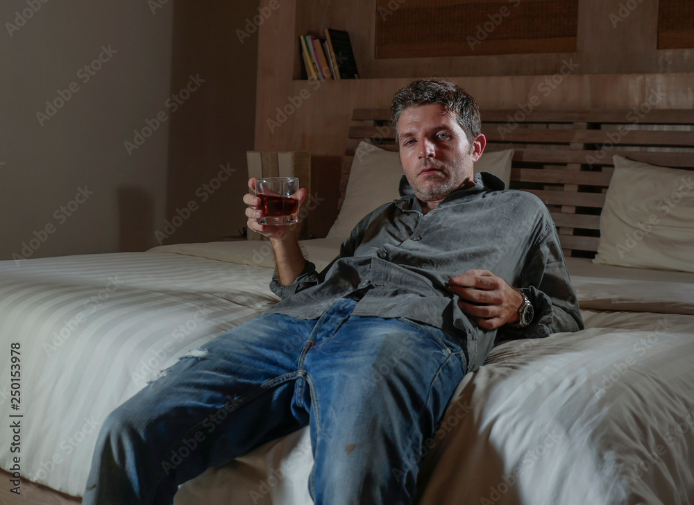 wasted drunk man drinking whiskey glass at home lying on bed hammered ...