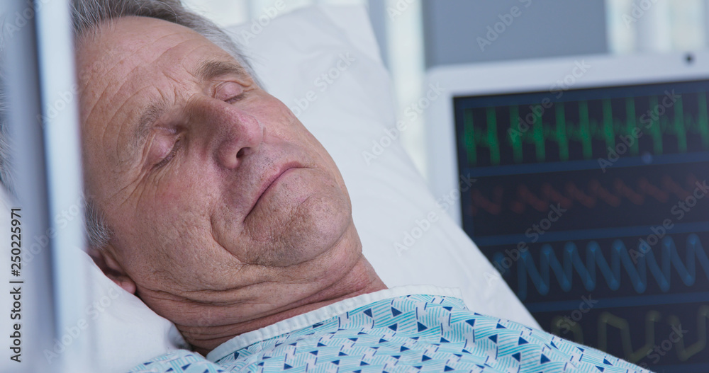 Close up of senior Caucasian male patient lying in hospital bed ...