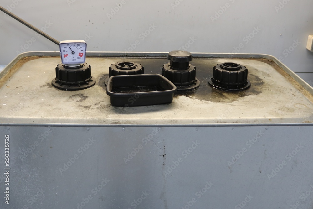 Pouring the used engine oil to waste oil tank. A large collection of ...