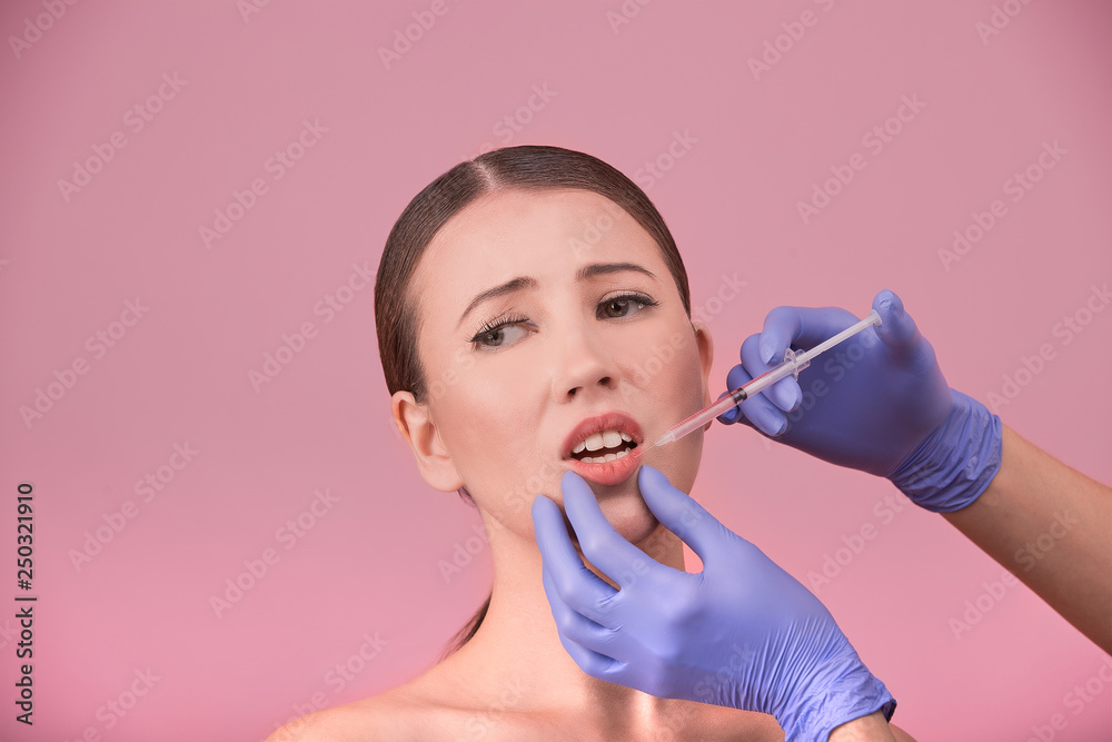 Beautiful woman face and beautician hands with syringe. Doctor makes ...
