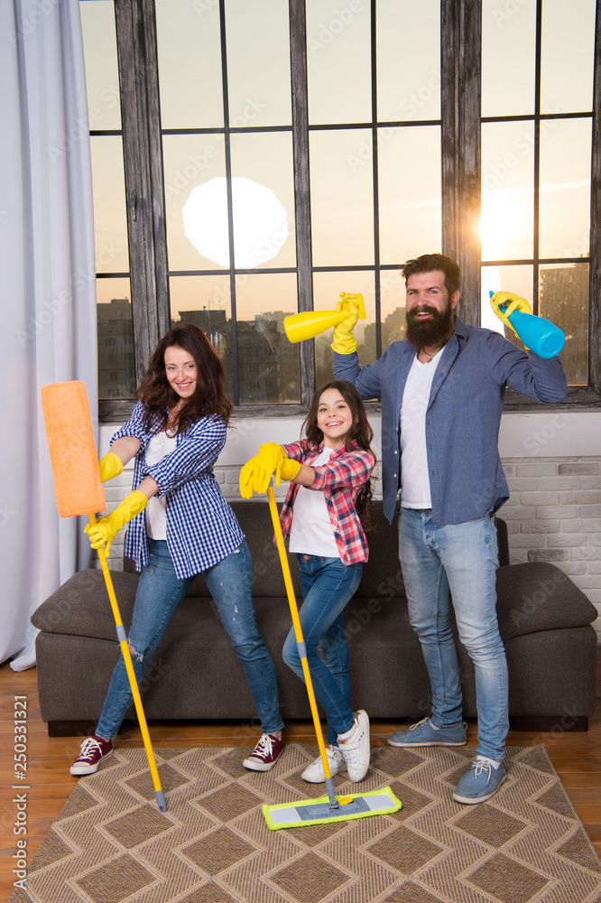 Family mom dad and daughter with cleaning supplies at living room. We ...