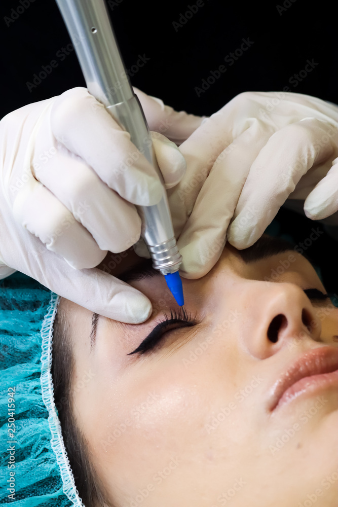 Permanent make-up tattoo. Cosmetologist applying permanent make up ...