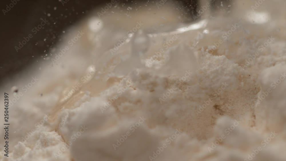 SLOW MOTION, MACRO, DOF: Transparent liquid flowing down a heap of ...