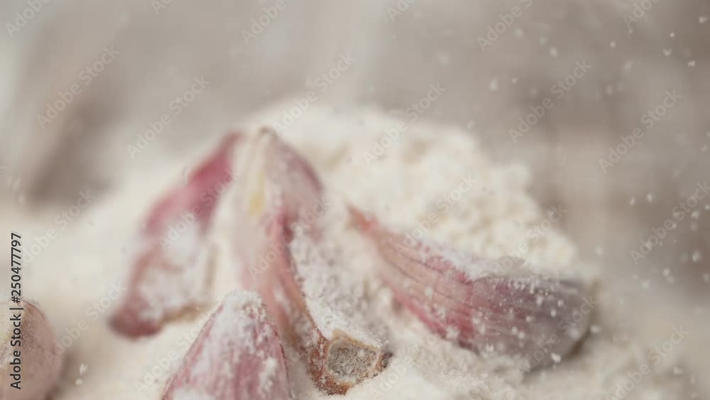 MACRO, DOF, SLOW MOTION: Purple unpeeled cloves sitting in a heap of ...