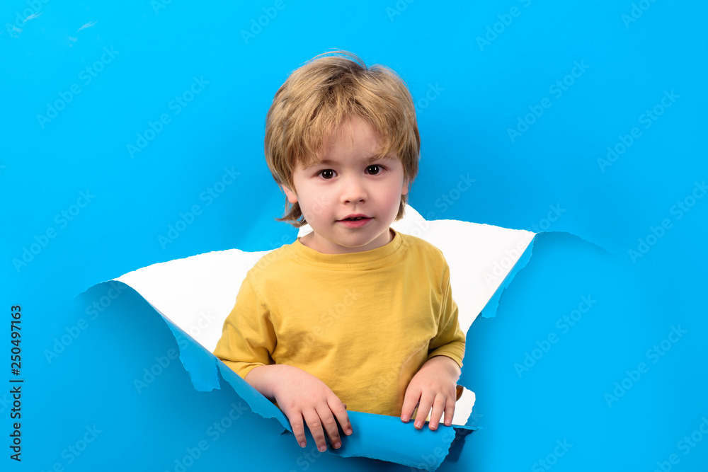 Happy childhood. Boy breaking through paper. Happy kid. Boy looking ...