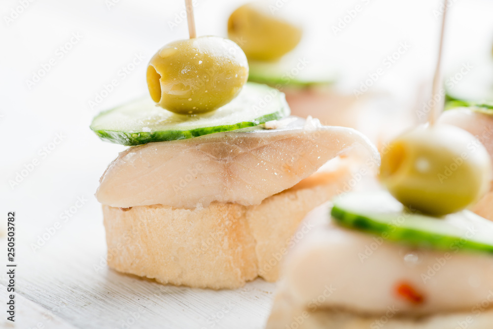 canape with a piece of fish and olive on a light background Stock Photo ...