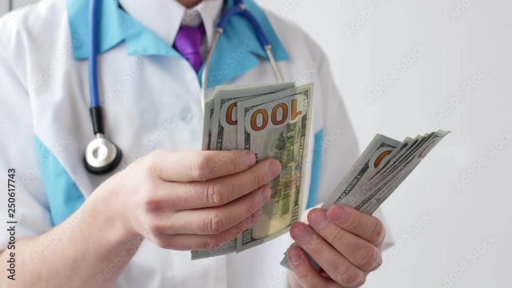 Male medical doctor counting hundred dollars banknotes close-up. Medic ...