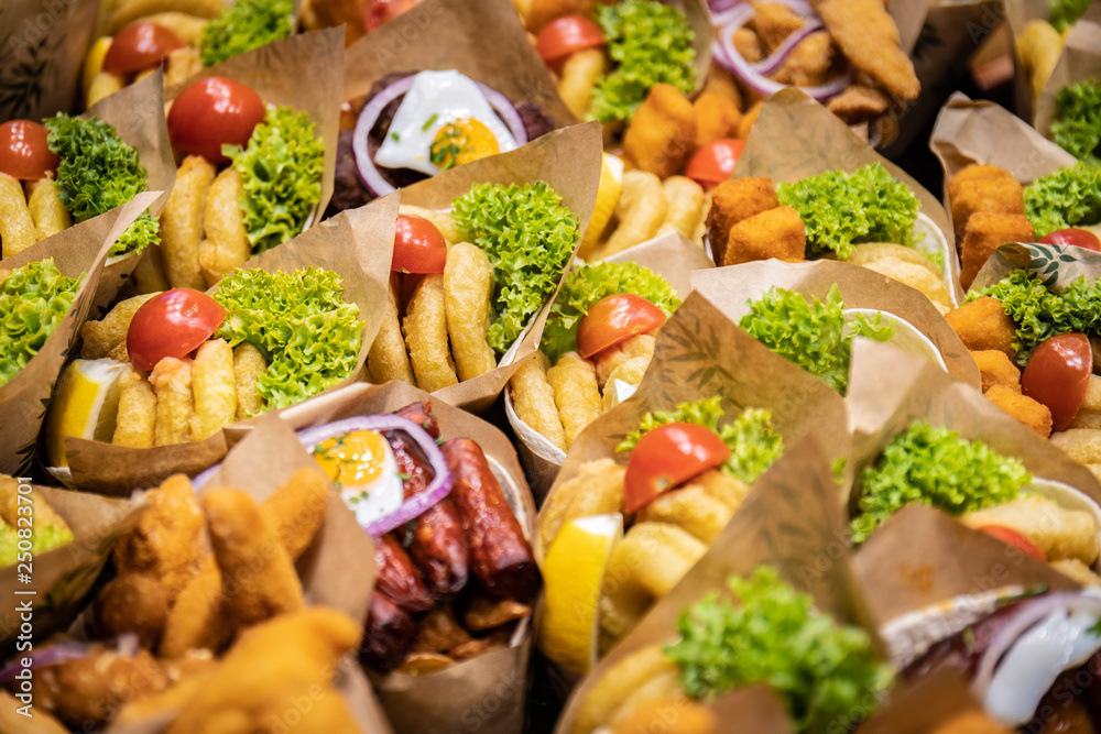 Crowded street fast food. Delicious snack cone with squid sausage quail ...