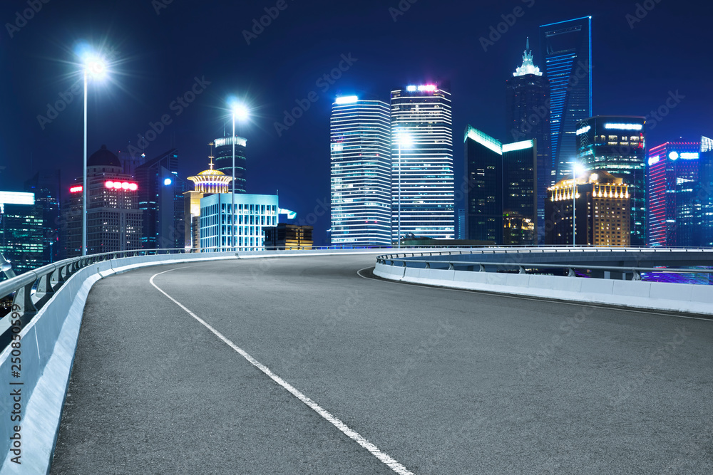 High speed corner overpass asphalt road with modern skyscraper , night ...