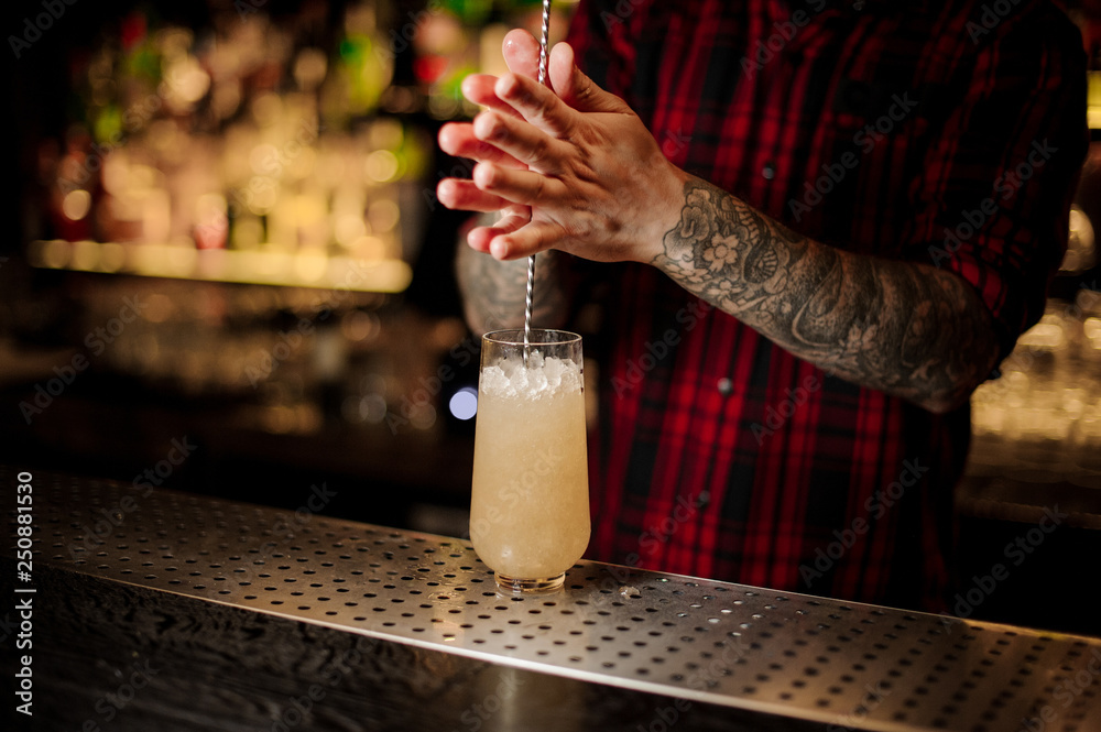 Bartender stirring a Trinidad Swizzle cocktail with the spoon Stock ...