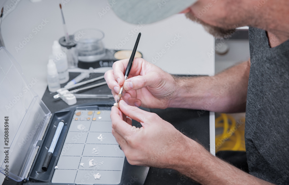 Dental Lab process - Applying color shade to tooth crown Stock Photo ...
